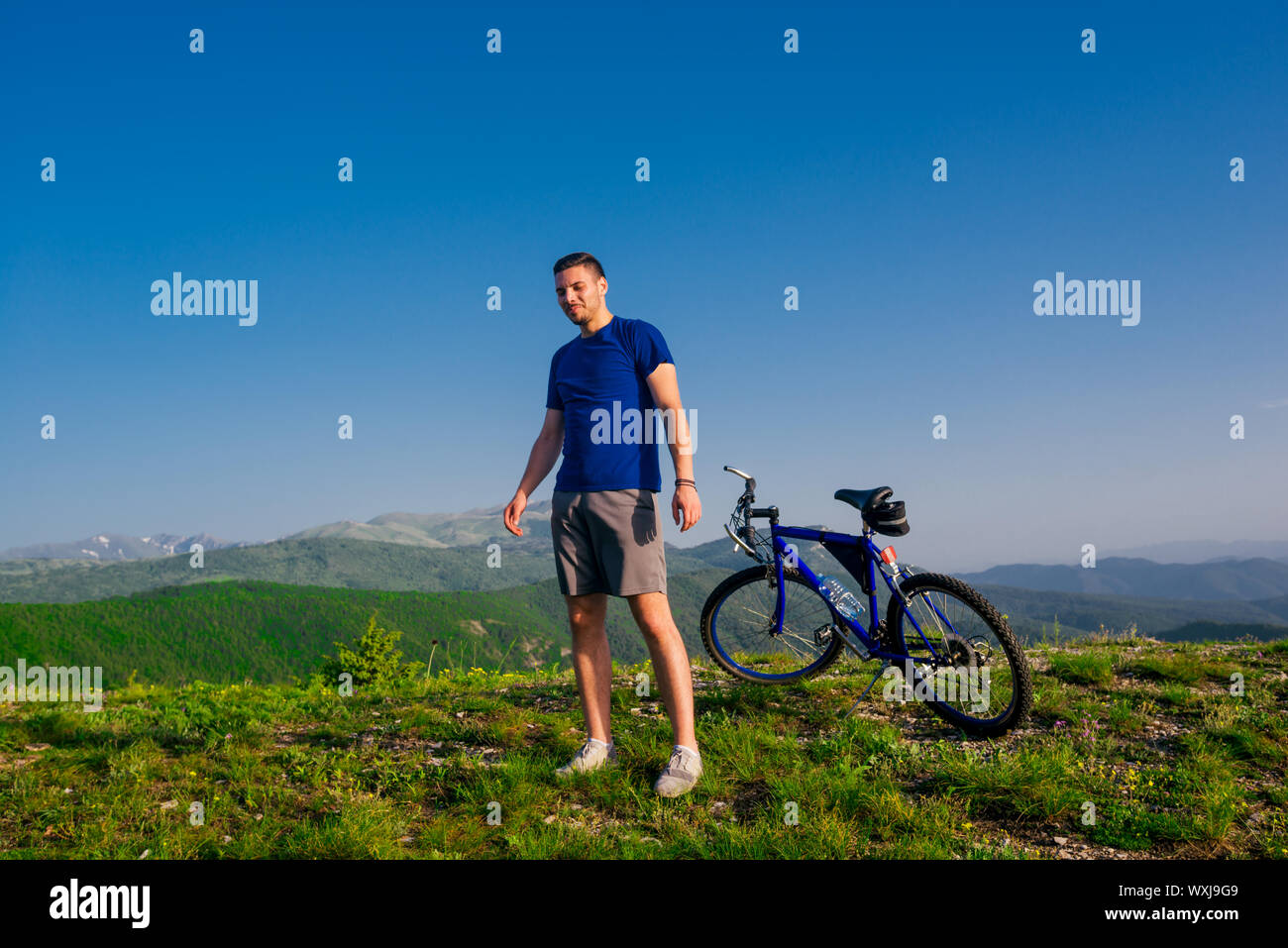 Adventurous Cyclist riding his mountain bike at the edge of a cliff, on ...