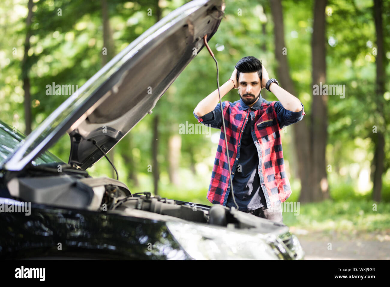 Man looking at engine of car Stock Photo - Alamy