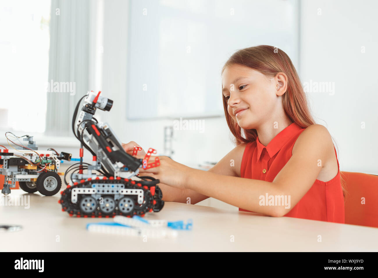 Robotics. Girl sitting making robot happy Stock Photo - Alamy