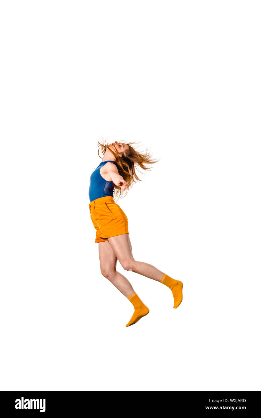 Happy young woman dancing against plain white background Stock Photo ...