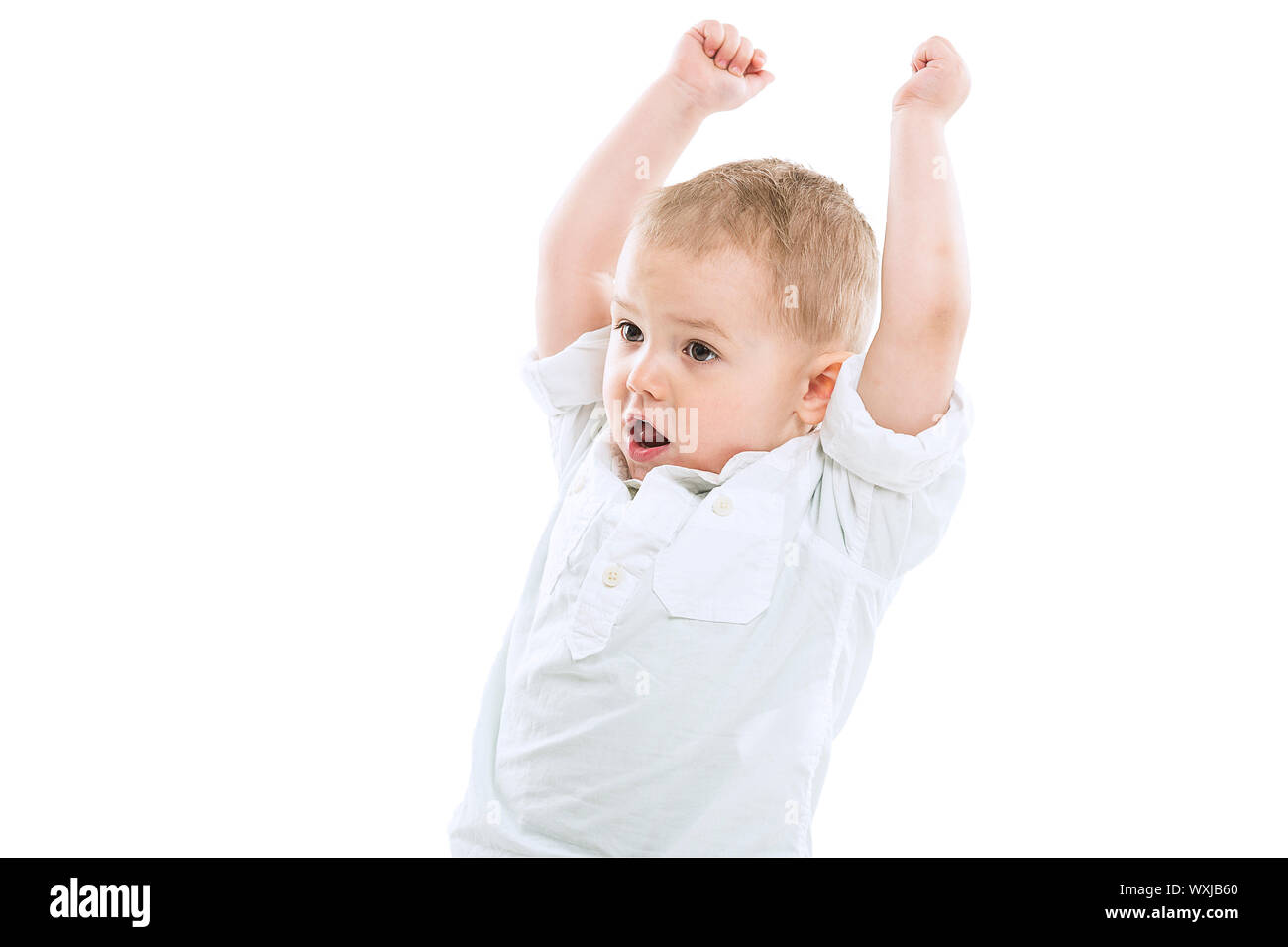 Excited playful handsome little boy standing with raised arms and his ...