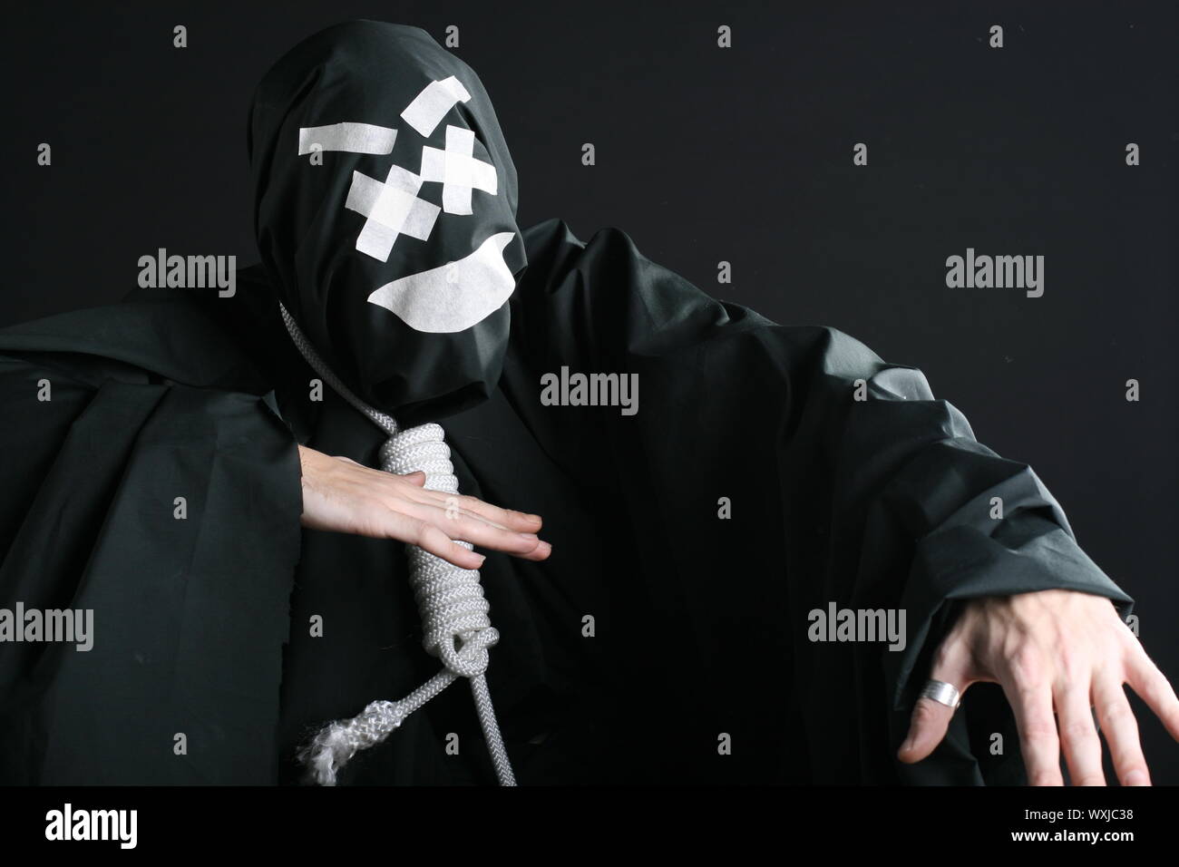 Black mime with rope on neck on black background Stock Photo - Alamy