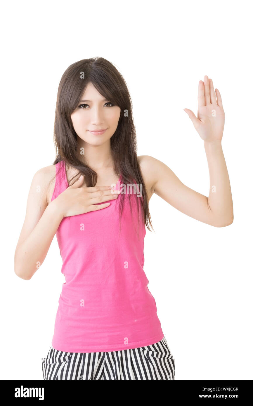 Asian young woman give a gesture of swear. Isolated on the white ...