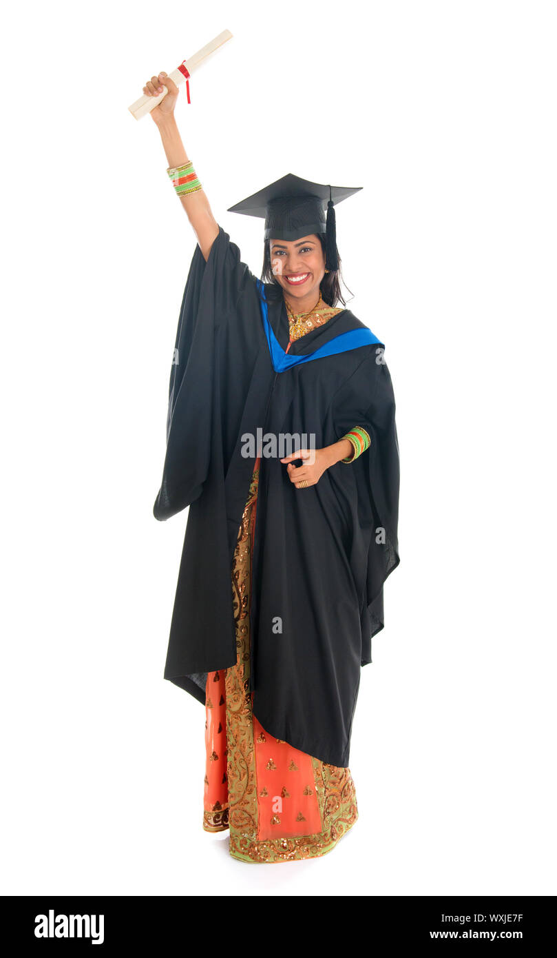 Full length happy Indian university student in graduation gown and cap ...