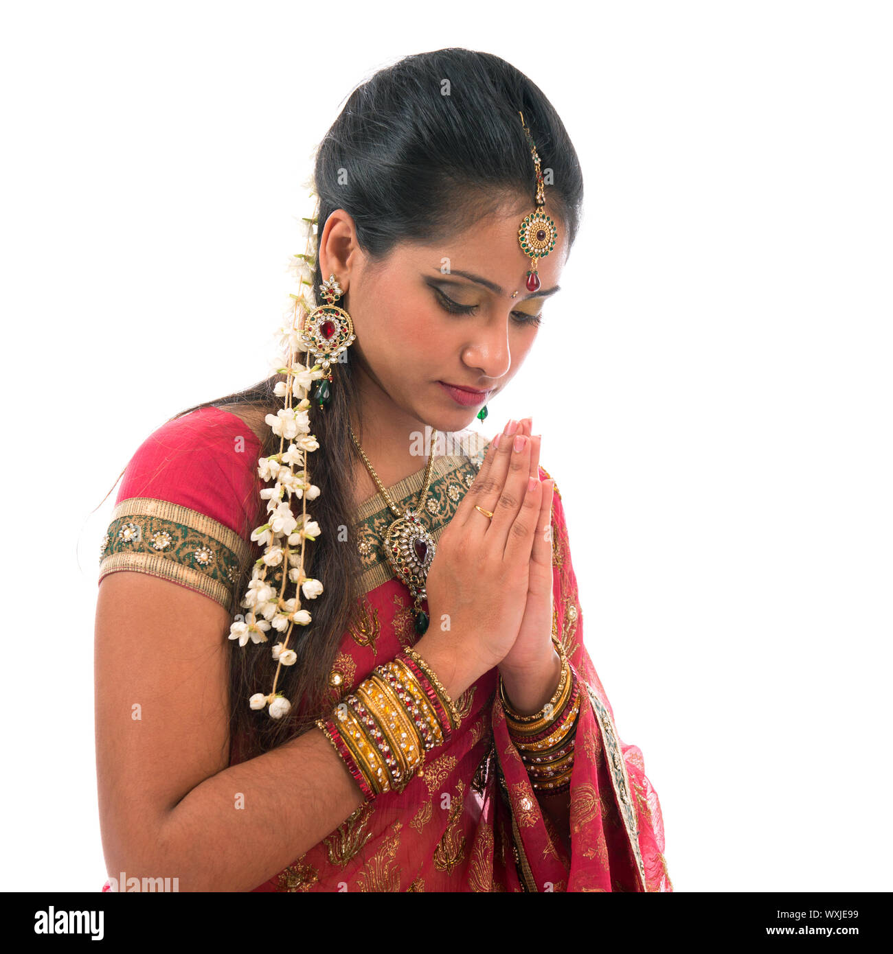 Portrait of beautiful young Indian woman prayer in traditional sari ...