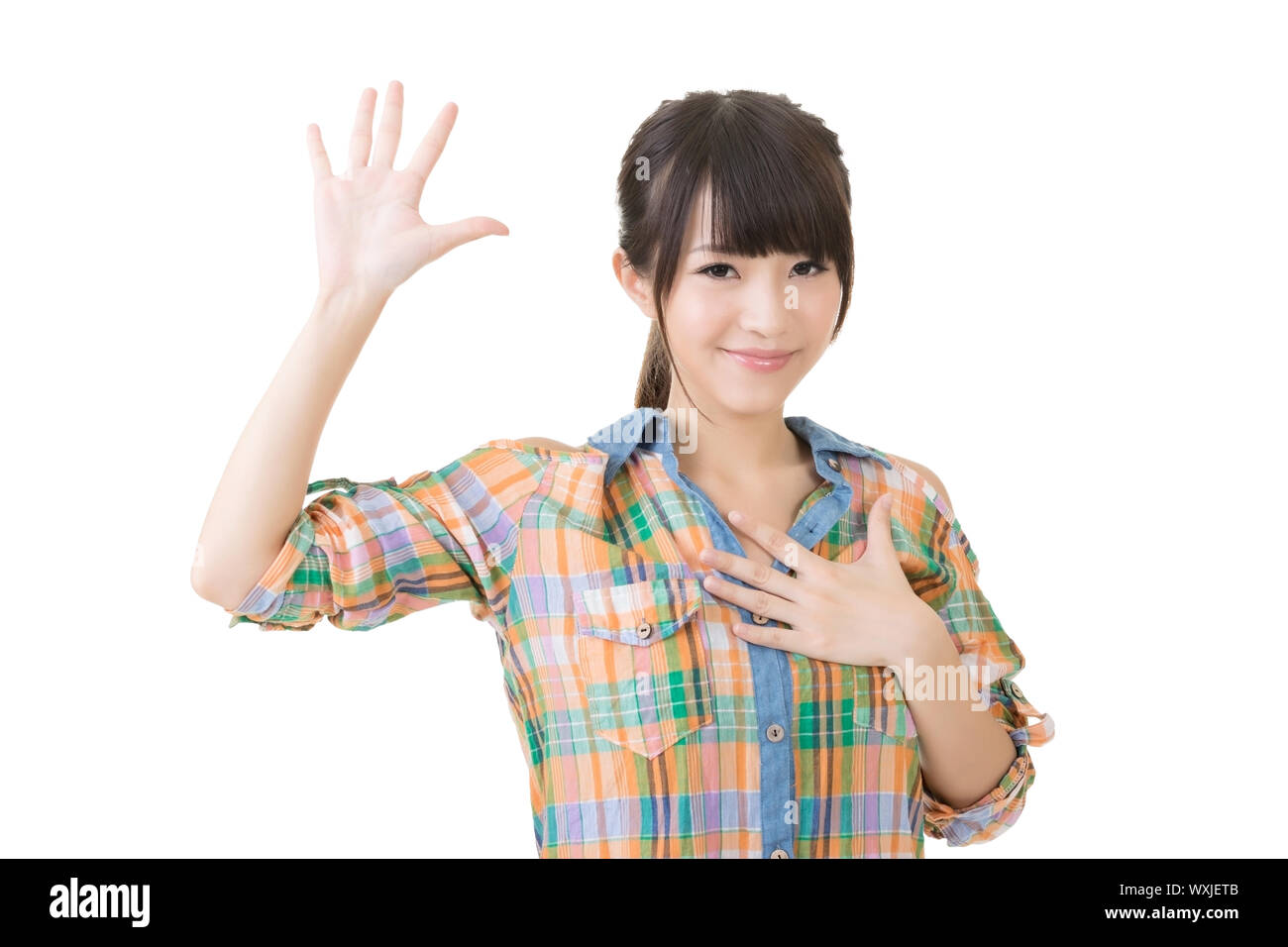 Asian young woman give a gesture of swear. Isolated on the white ...