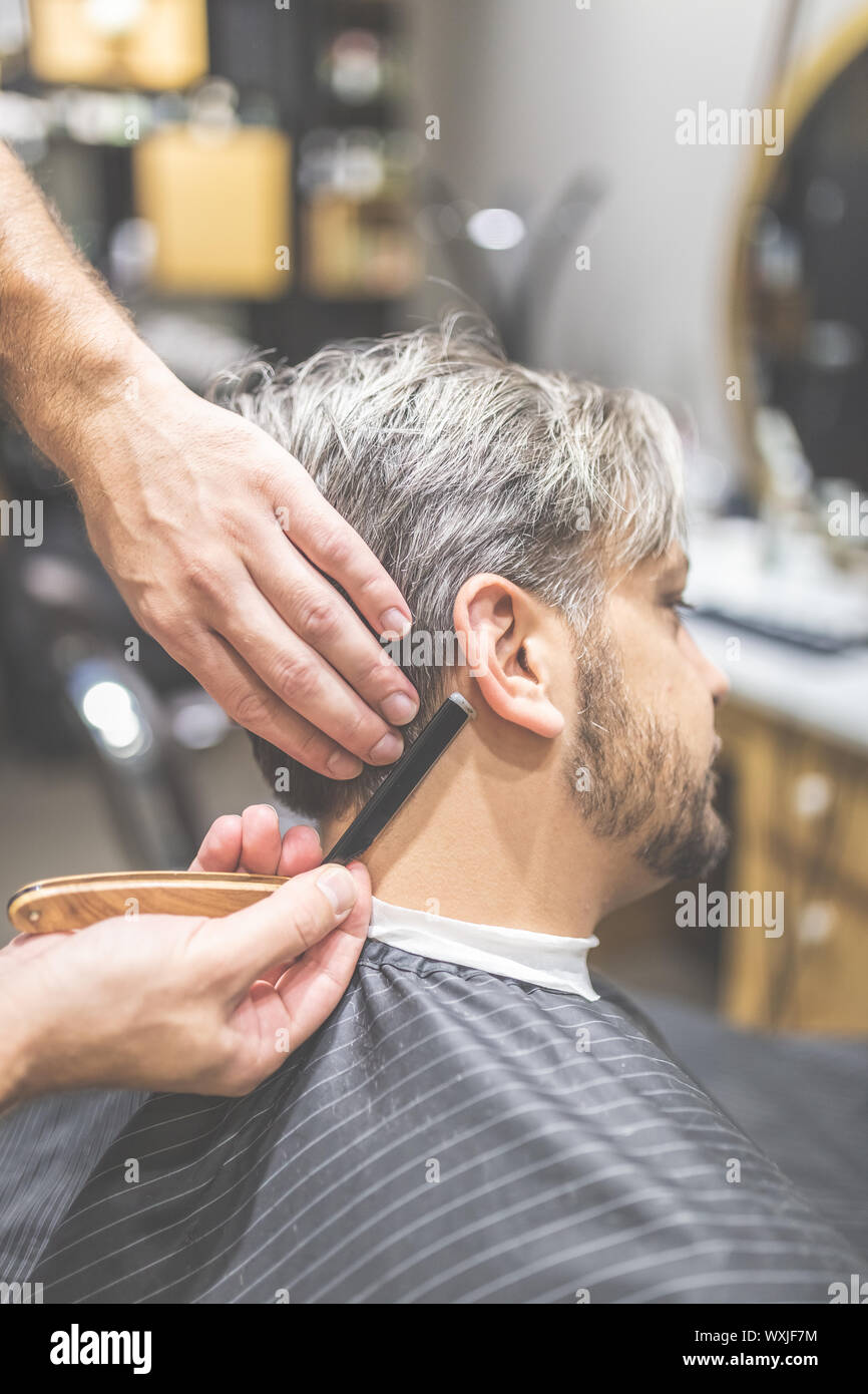 Hands of barber holding razor and shaving a client Stock Photo - Alamy