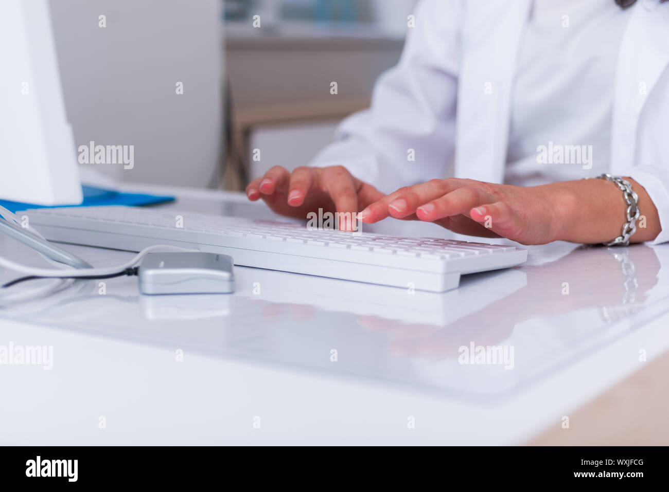 Close up hands of a female physician ( nurse ) typing on her white ...
