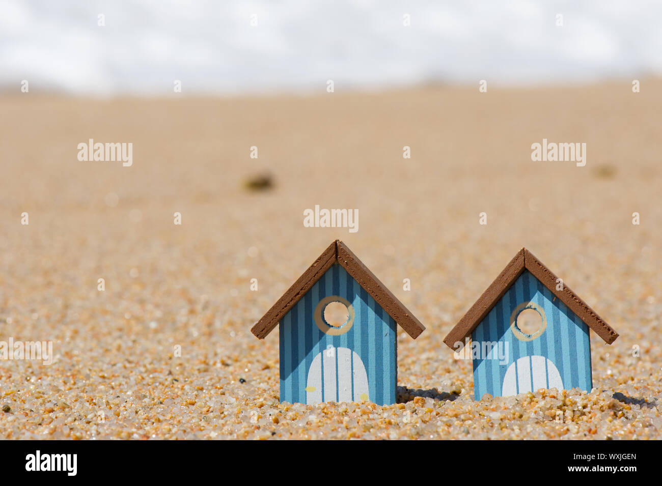 Miniature beach huts with the water line Stock Photo - Alamy