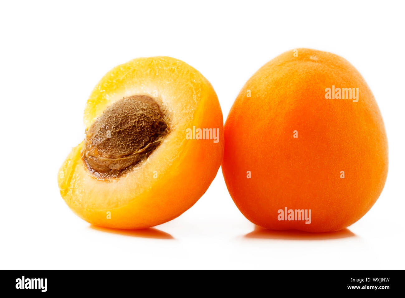 one apricot and a half on white background Stock Photo - Alamy