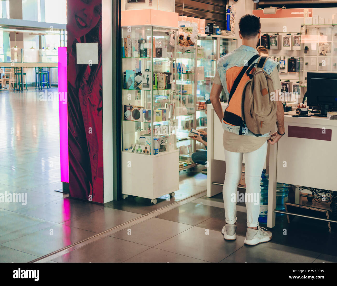 Young passenger standing at airport stall Stock Photo - Alamy