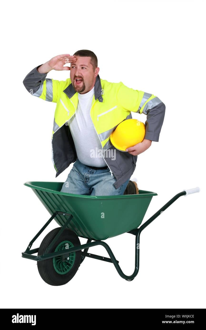 Construction worker in a wheelbarrow Stock Photo - Alamy