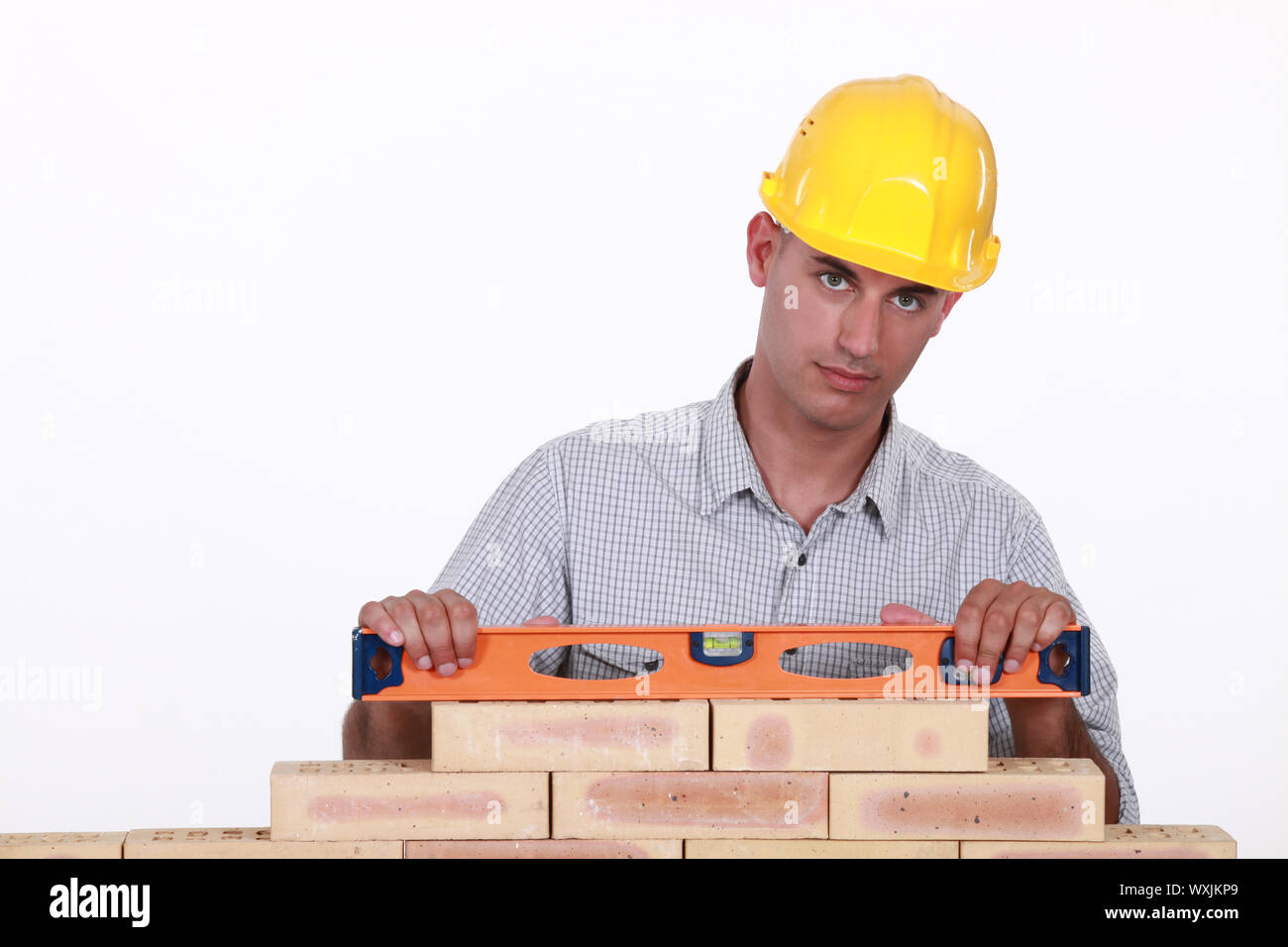 Bricklayer using a bubble level Stock Photo - Alamy