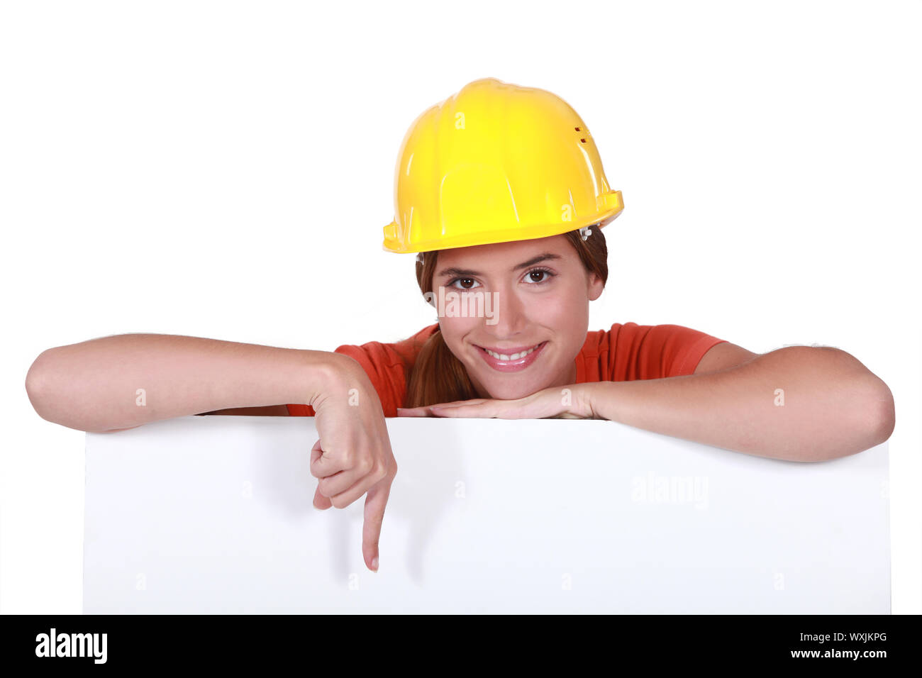 Female construction worker pointing to blank poster Stock Photo - Alamy