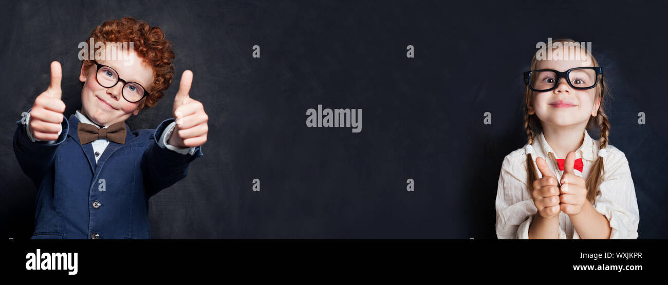 Happy funny children on chalkboard background with copy space. Happy ...