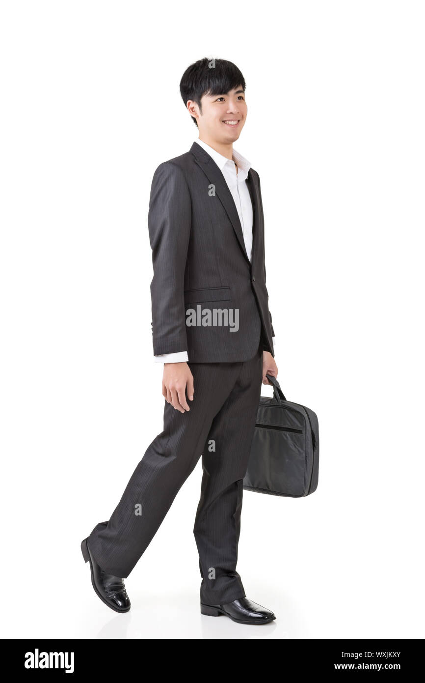 Young businessman hold briefcase and walk, full length portrait ...