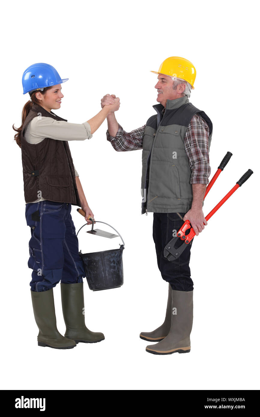 Male and female manual workers shaking hands Stock Photo - Alamy