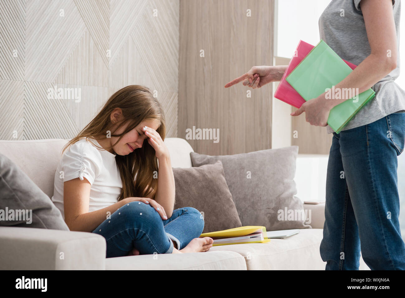 Mother scolds school crying daughter for homework. Girl sitting cross ...