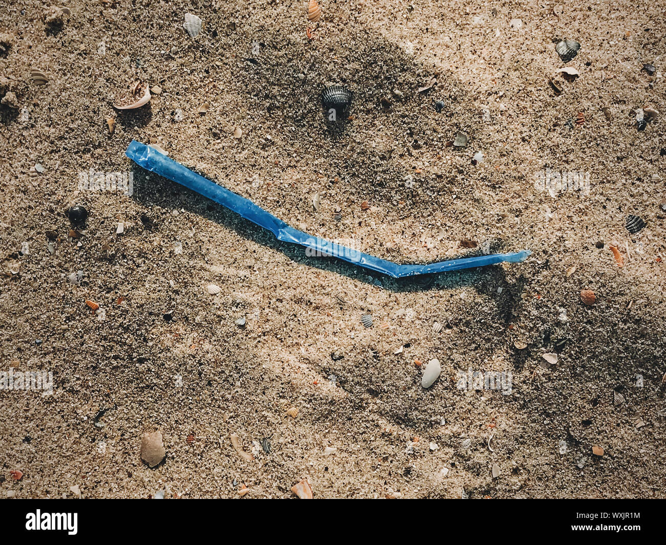 Single use plastic straw in sand, marine trash on the beach.Plastic ...