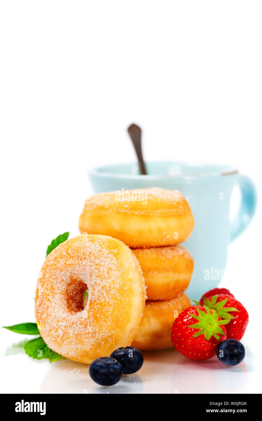 Coffee break with fresh berries and sugary donuts over white background ...