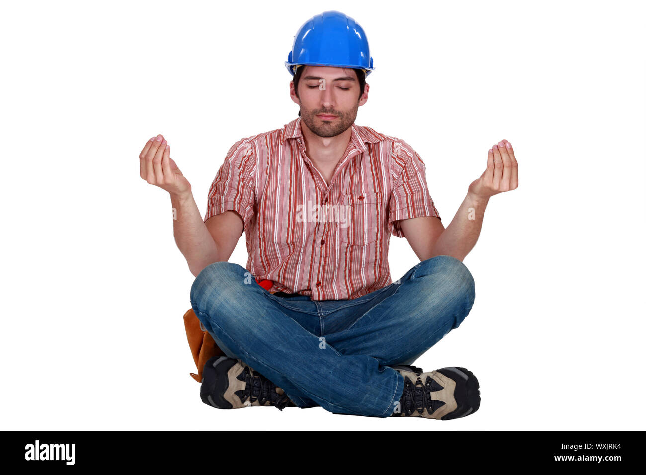 Builder sitting in yoga position Stock Photo - Alamy