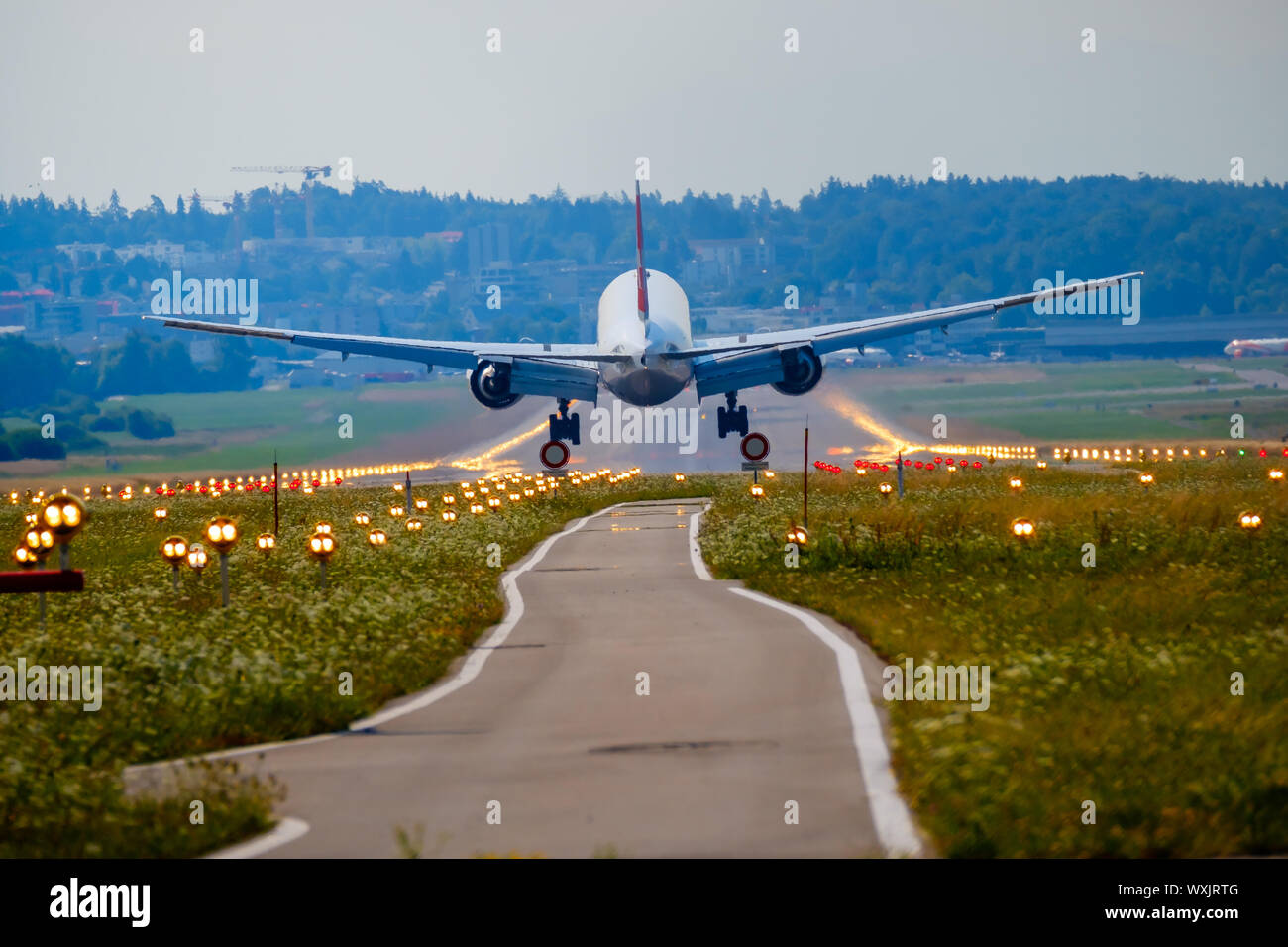 Airplane landing at airport runway, back view Stock Photo - Alamy
