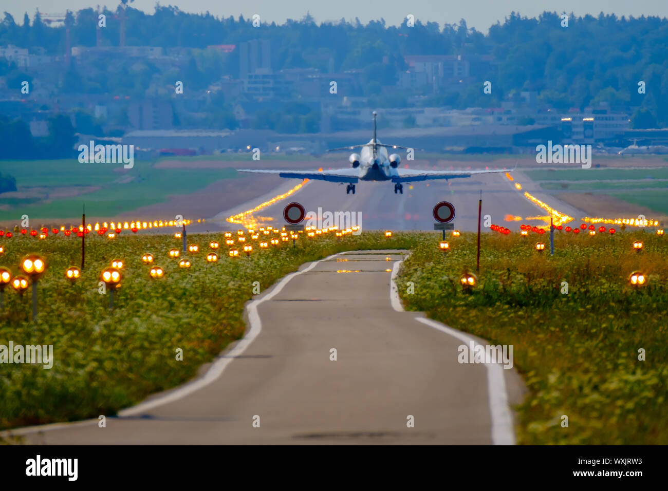 Airplane landing at airport runway, back view Stock Photo - Alamy