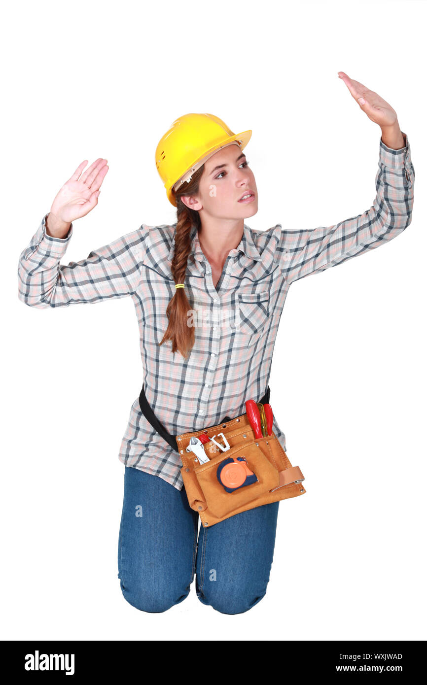 Female laborer kneeling with hands up Stock Photo - Alamy