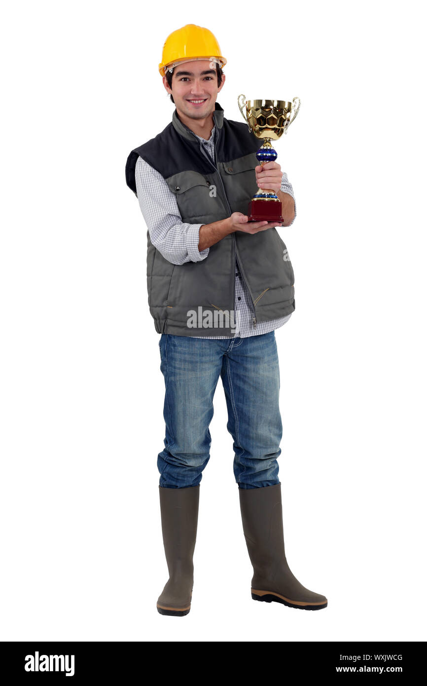 Builder holding trophy Stock Photo - Alamy