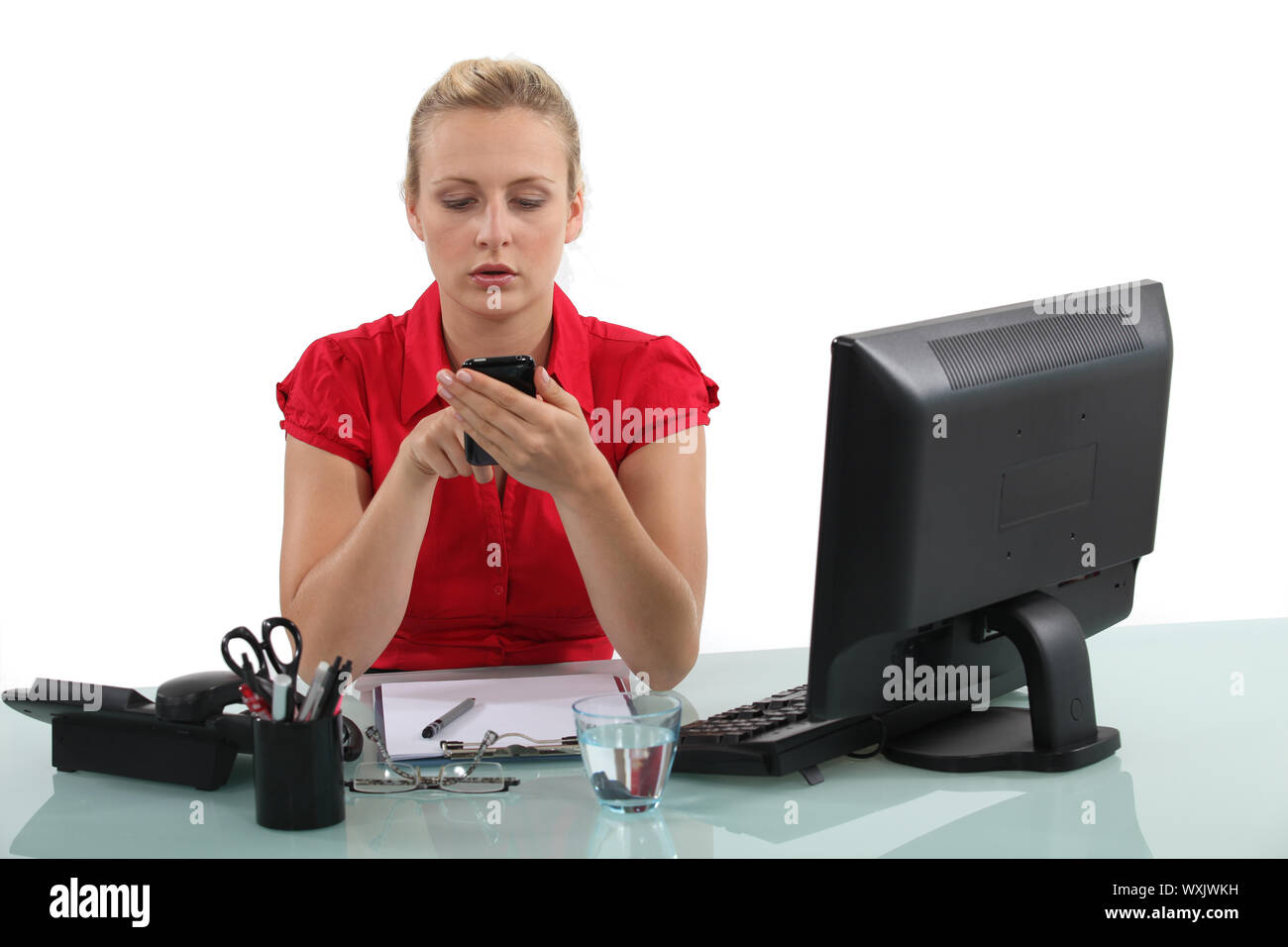 Blond receptionist typing text message Stock Photo - Alamy