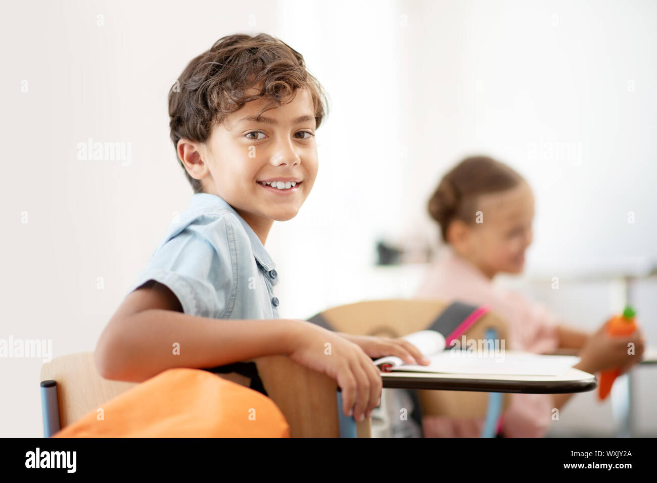 Dark-eyed boy smiling while having little break at school Stock Photo ...
