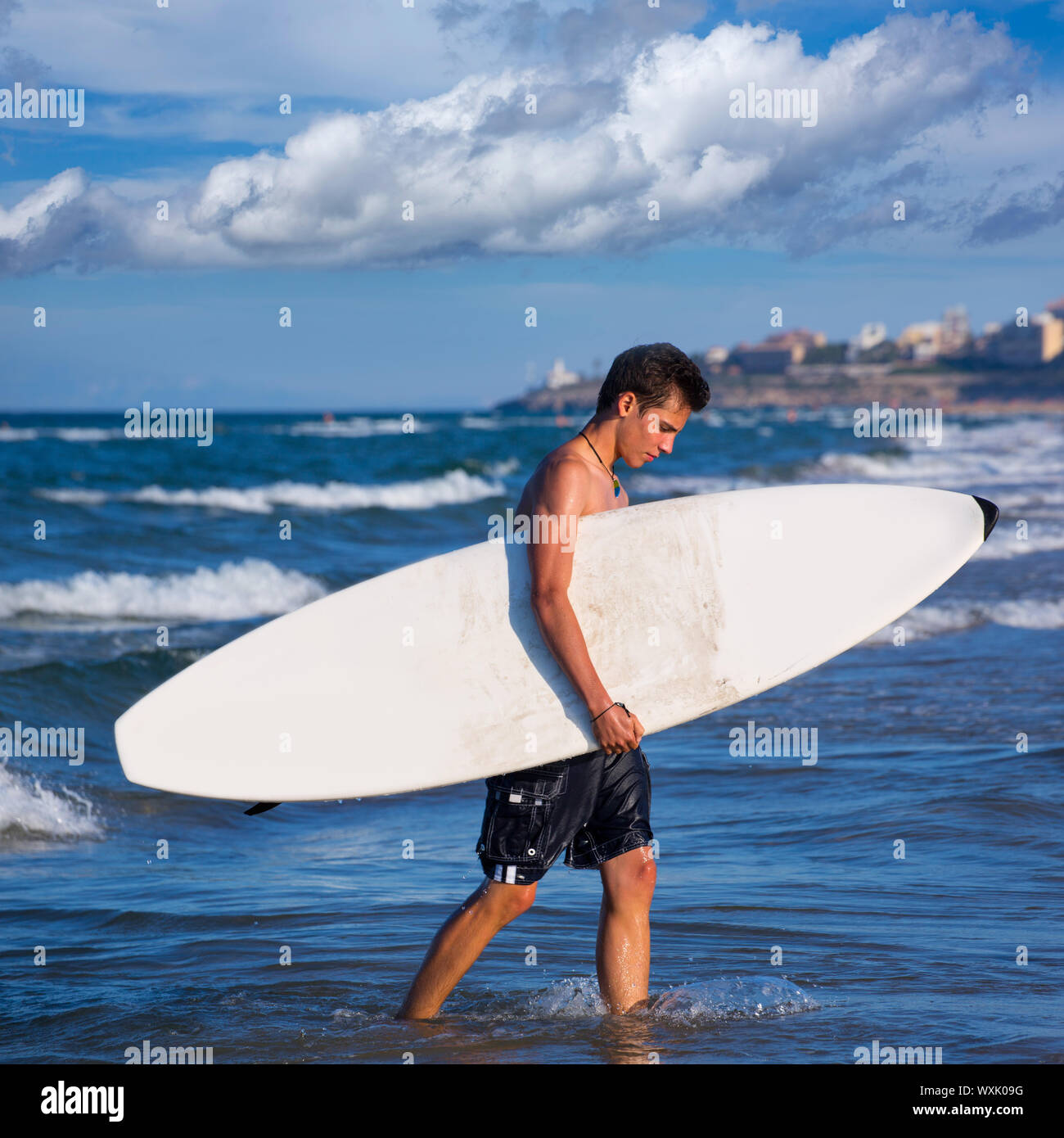 boy handsome surfer holding surfboard coming out from the waves Stock ...