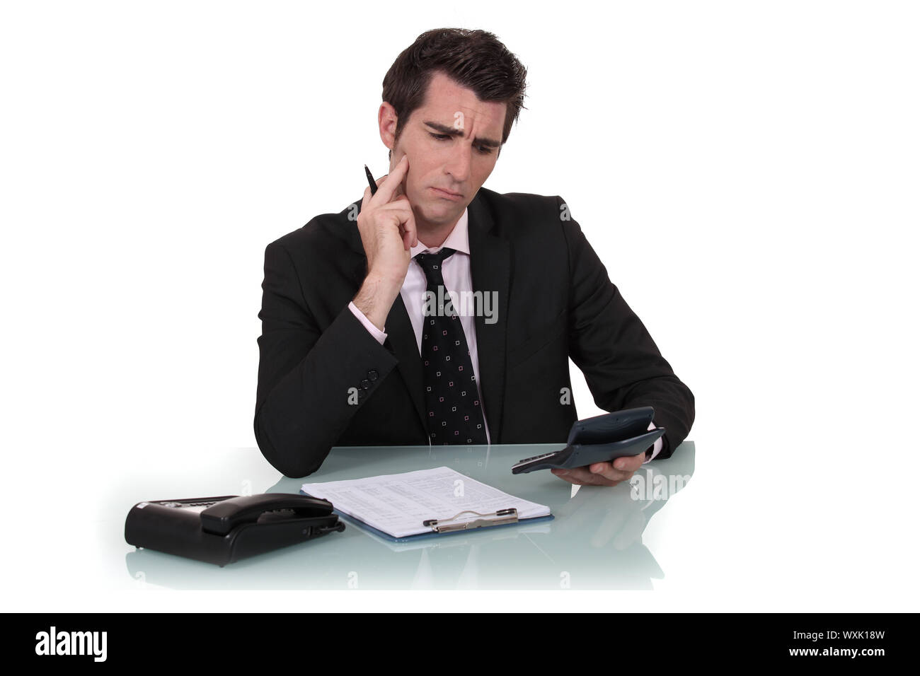 Confused man holding calculator Stock Photo - Alamy