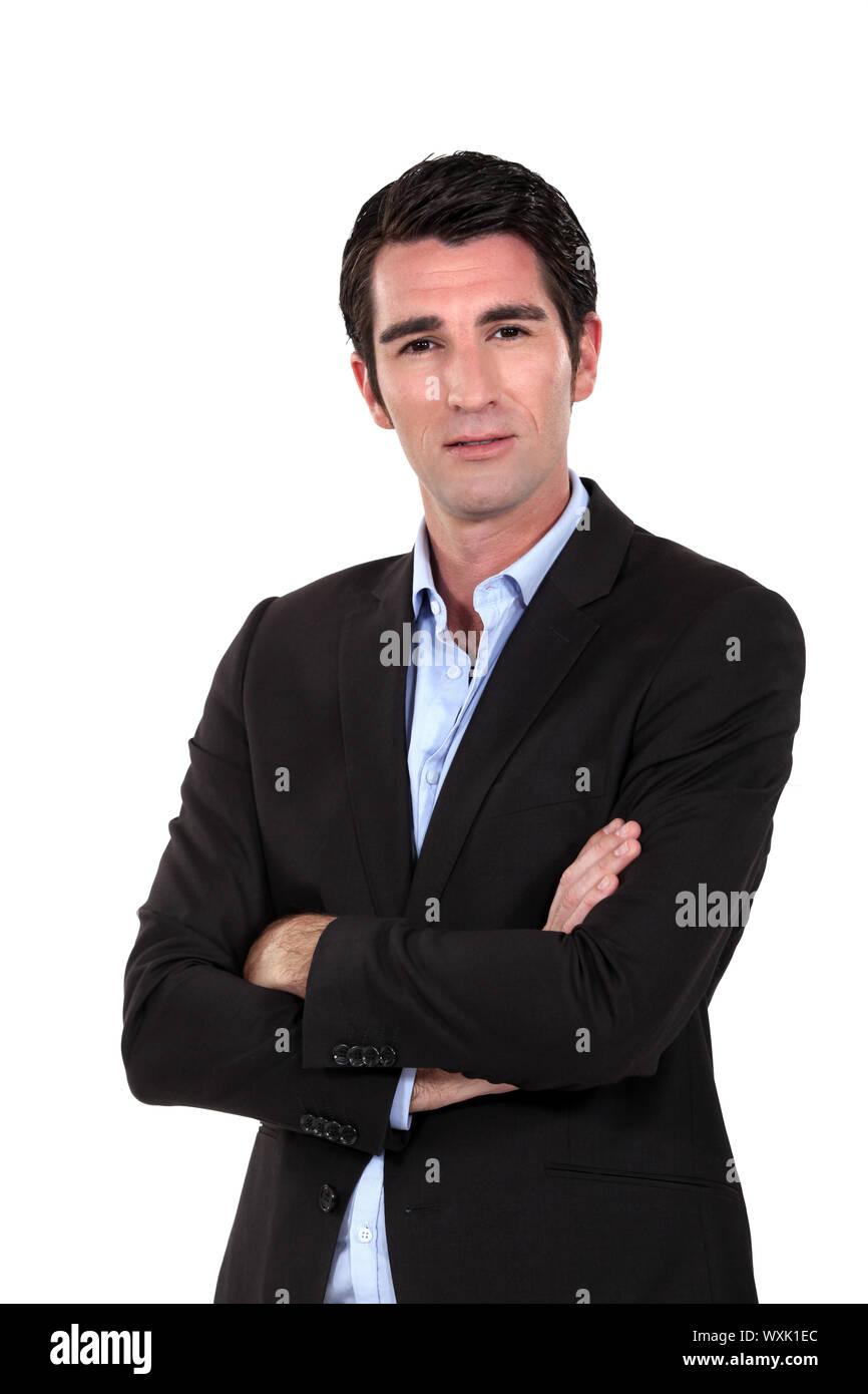 elegant man standing cross-armed against white background Stock Photo ...