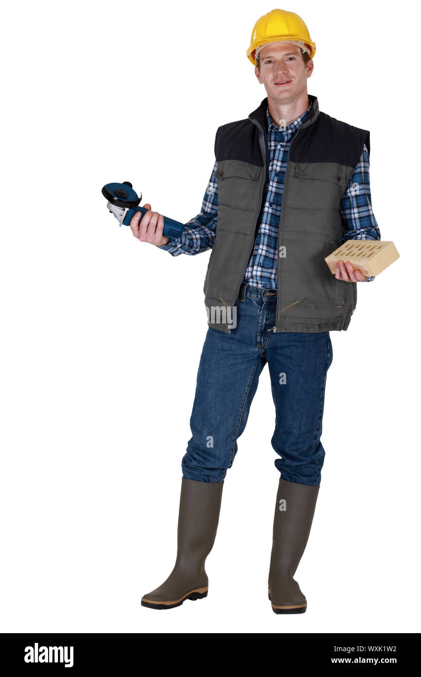 craftsman holding a brick and an electric saw Stock Photo - Alamy