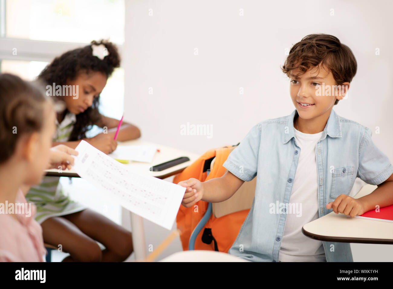 Girl giving her test with answers to her best friend Stock Photo - Alamy