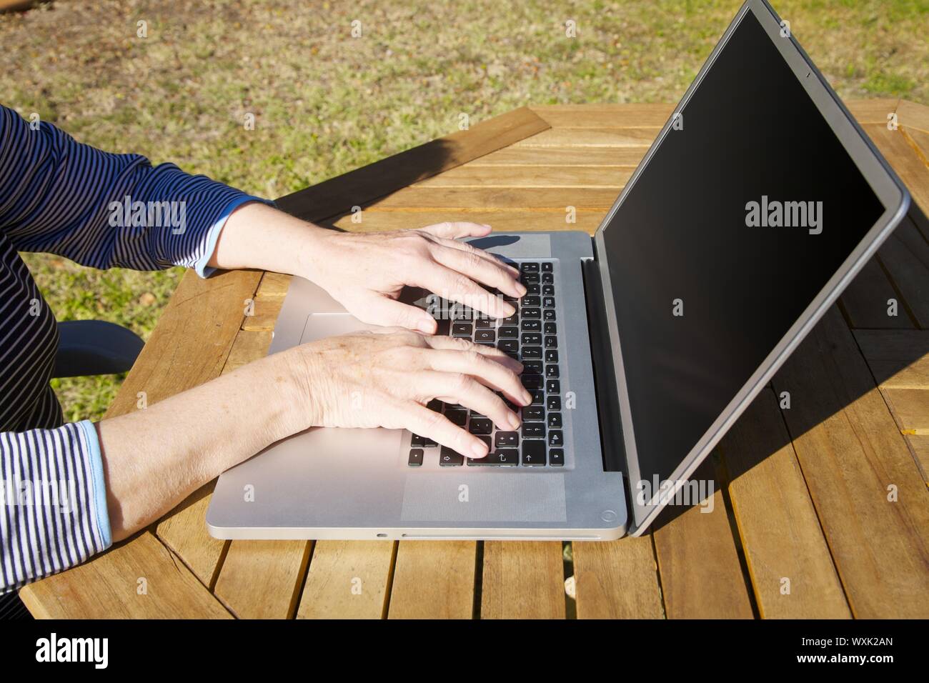 hands of old woman tapping on portable computer Stock Photo - Alamy