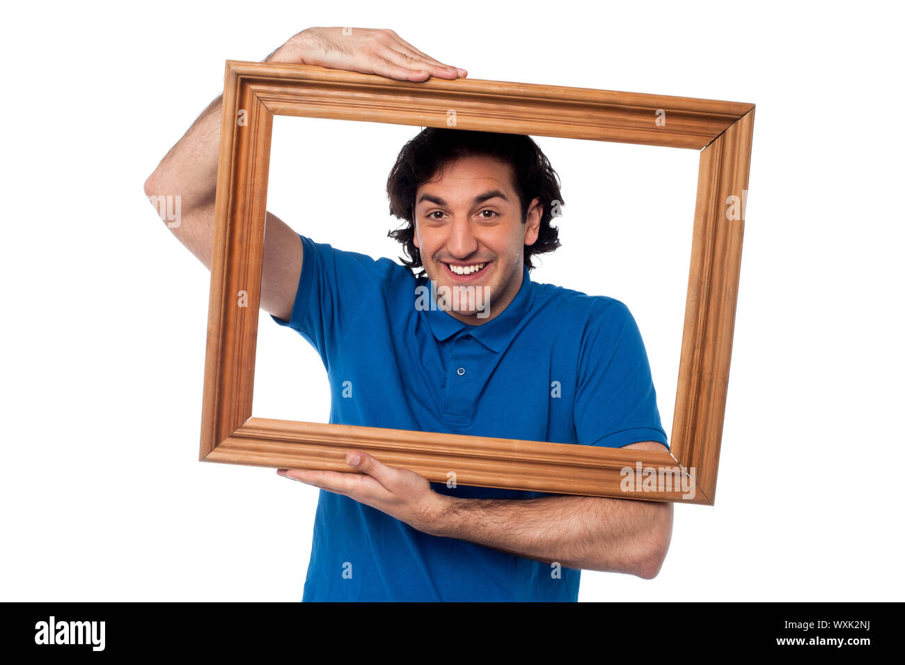 Smiling guy looking through picture frame Stock Photo - Alamy