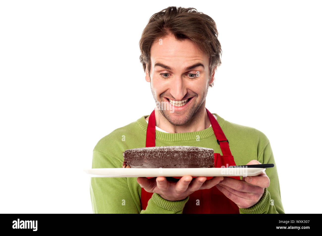 Male chef looking at cake excitedly Stock Photo - Alamy
