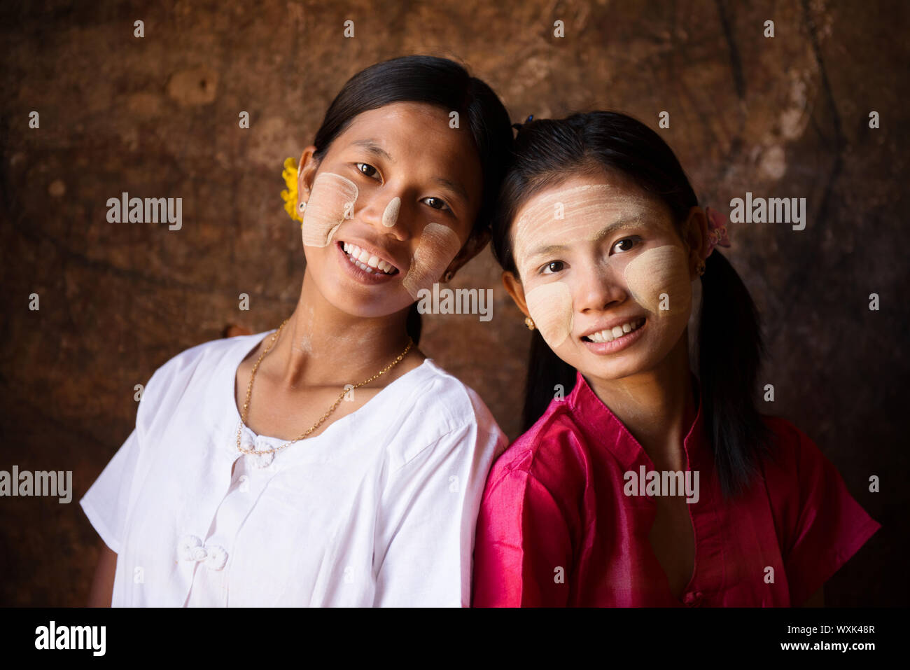 Portrait of two beautiful young traditional Myanmar girls smiling ...