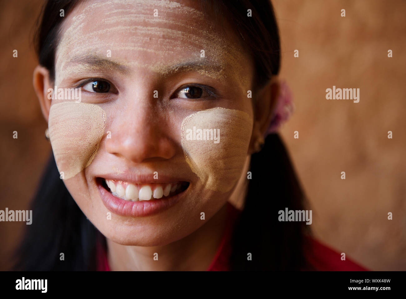 Portrait of beautiful young traditional Myanmar girl smiling. Close up ...