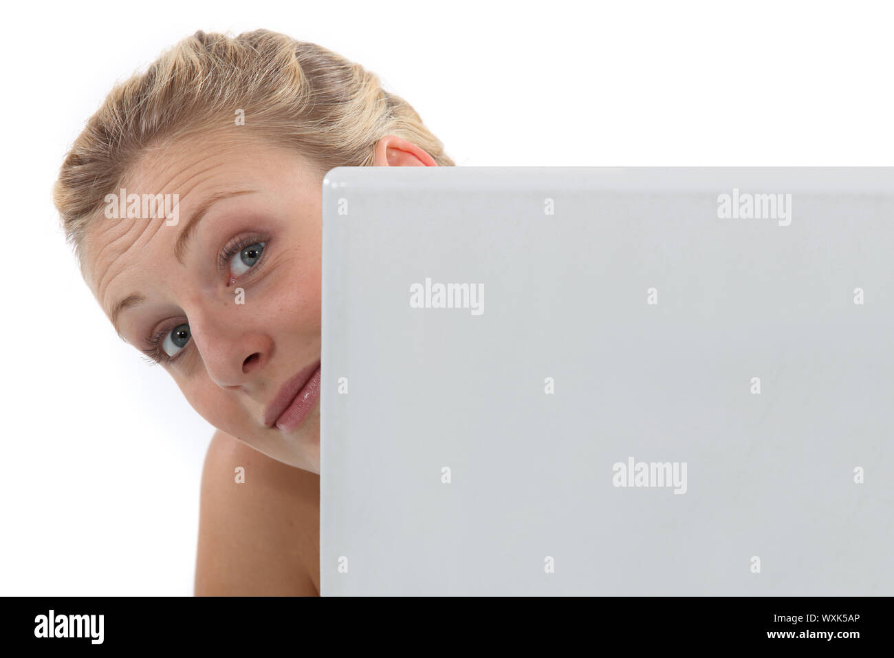 Woman peeking around a computer Stock Photo - Alamy
