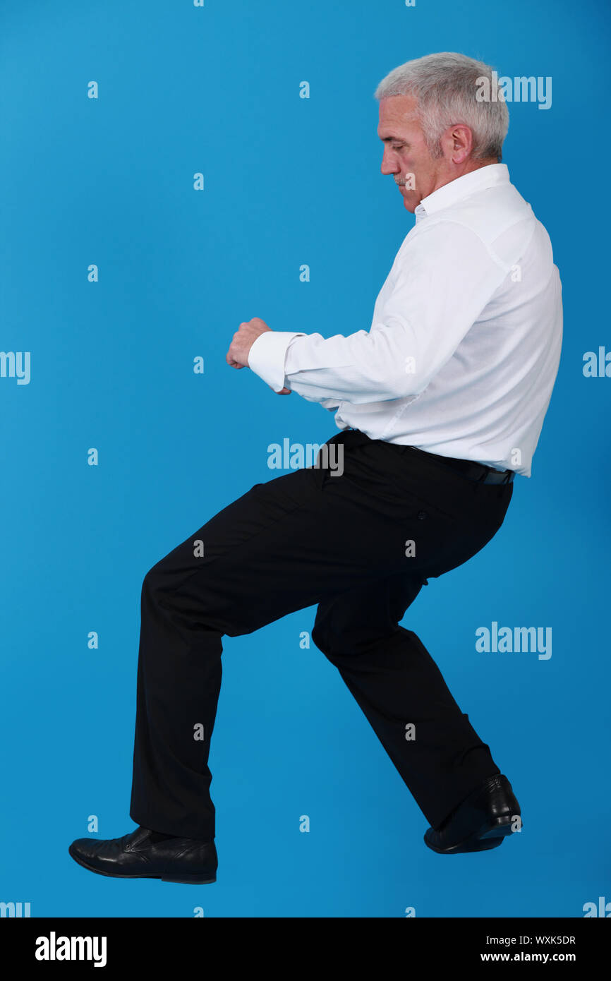 Senior man pulling invisible object Stock Photo - Alamy