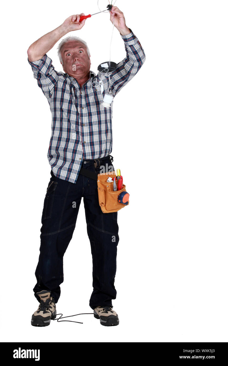 Electrocuted man fixing a light fixture Stock Photo - Alamy