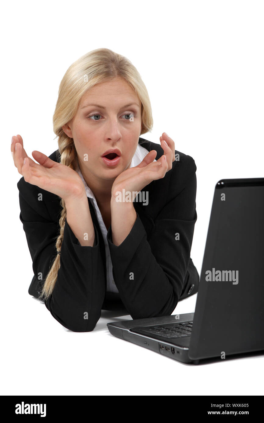 Shocked blond businesswoman sat in front of laptop Stock Photo - Alamy