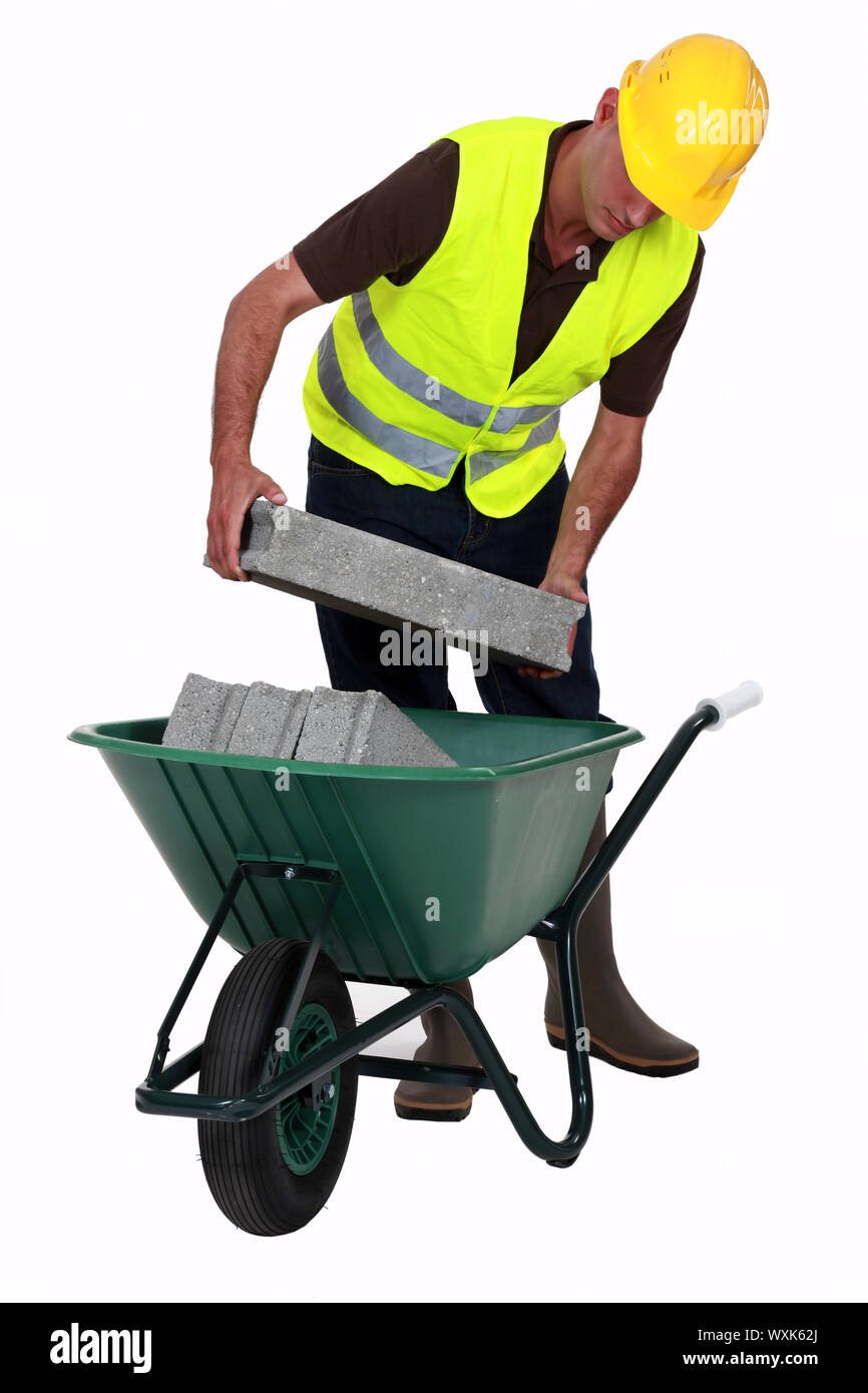craftsman putting stones in a wheelbarrow Stock Photo - Alamy