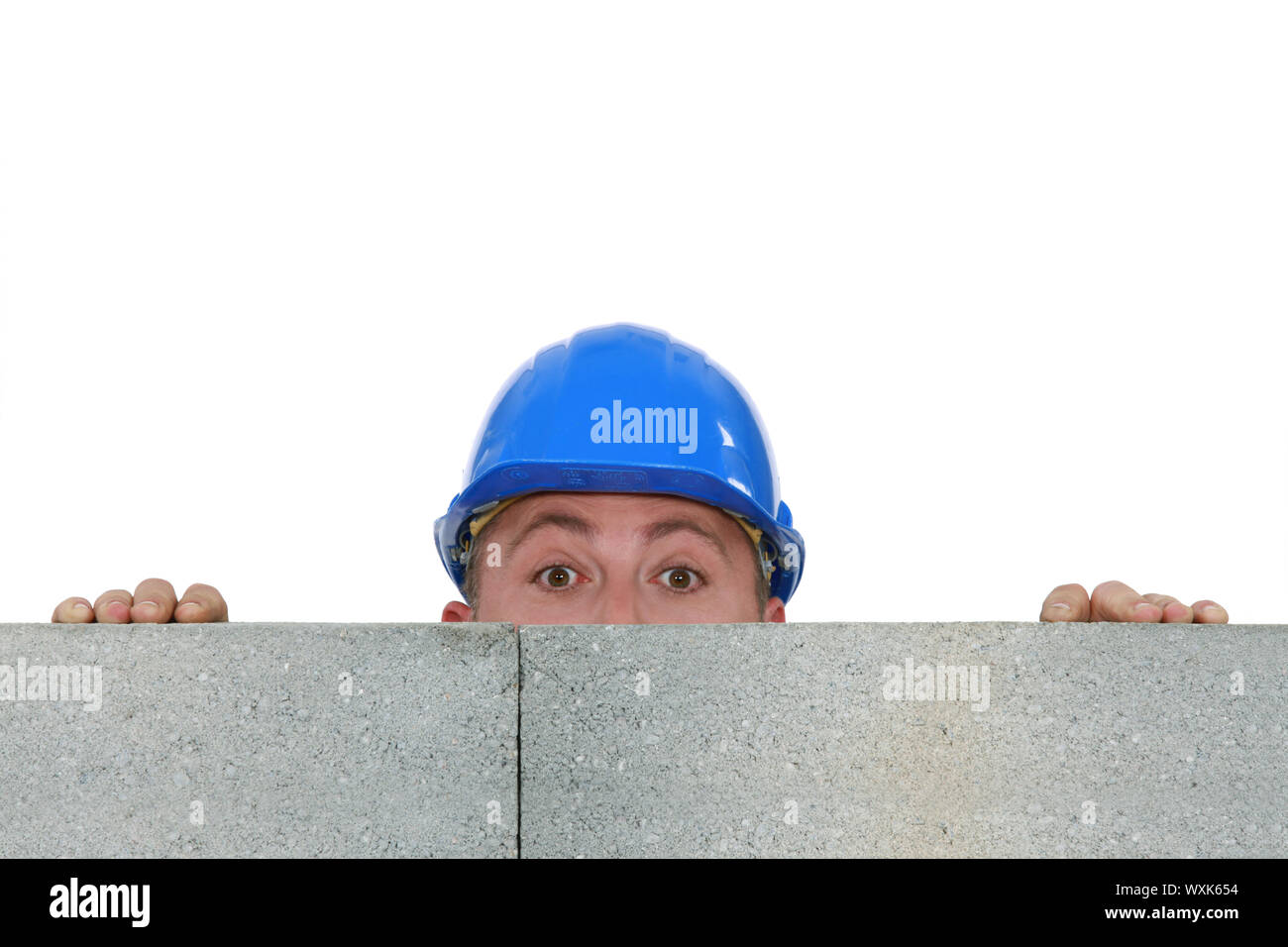 Construction worker hiding behind a wall Stock Photo - Alamy
