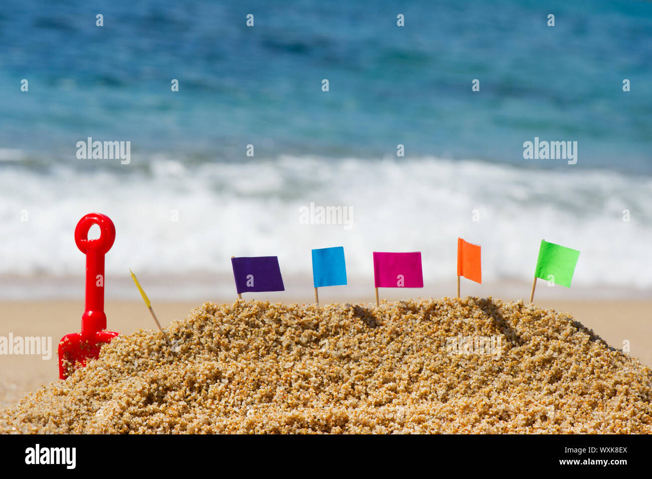 Sand castle with colorful flags at the beach Stock Photo - Alamy