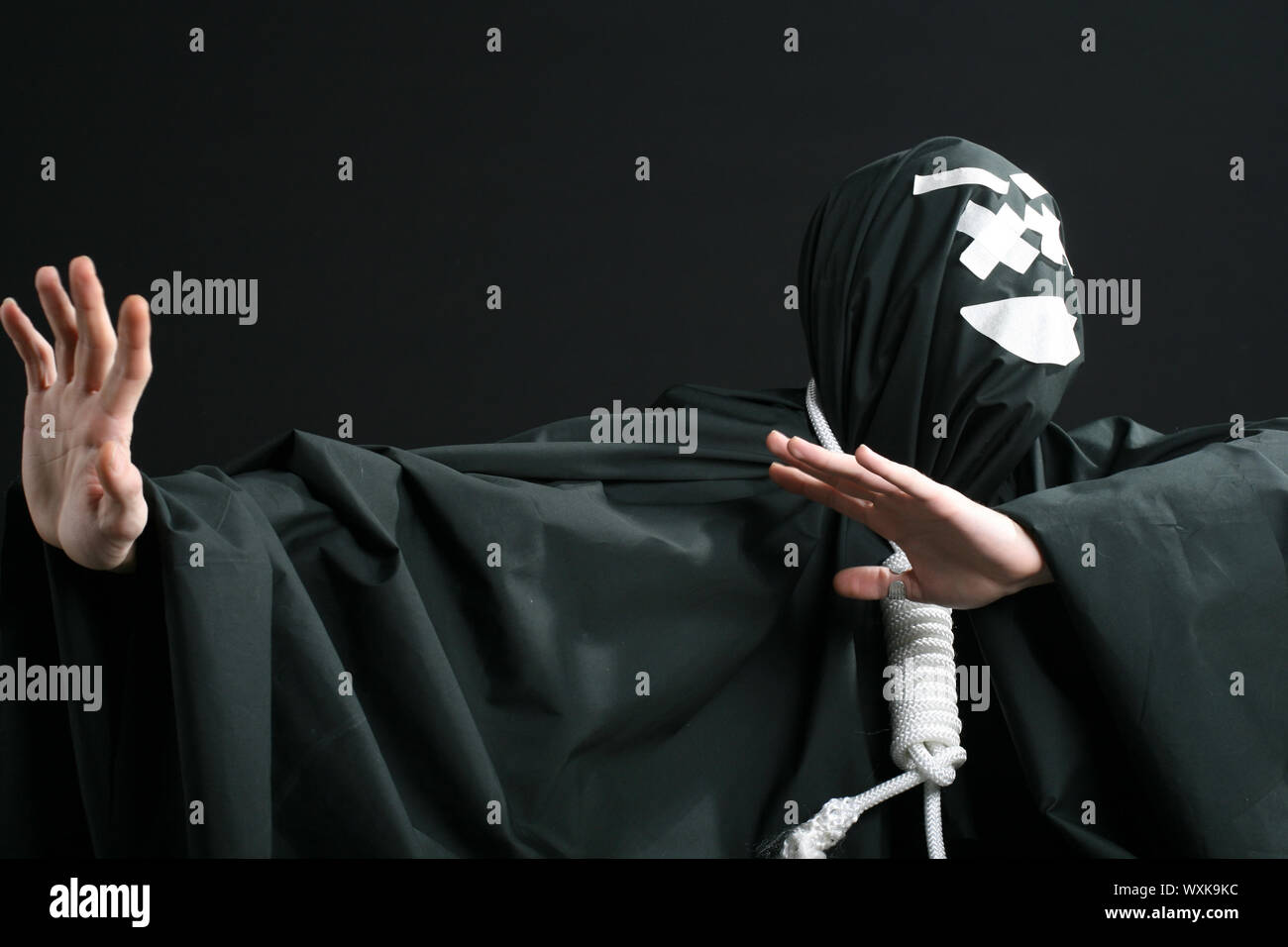 Black mime with rope on neck on black background Stock Photo - Alamy