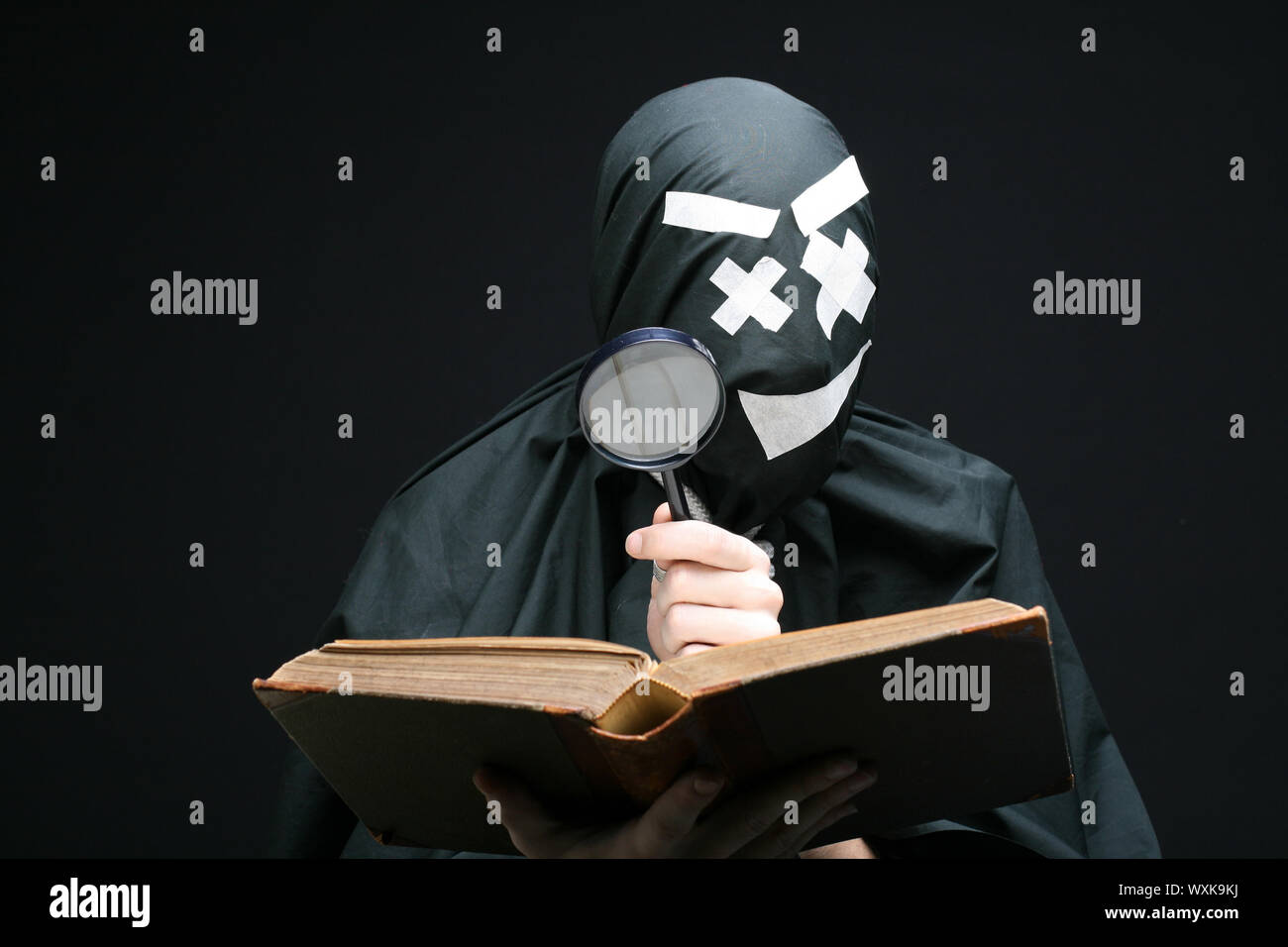 Black mime with rope on neck on black background reading book Stock ...